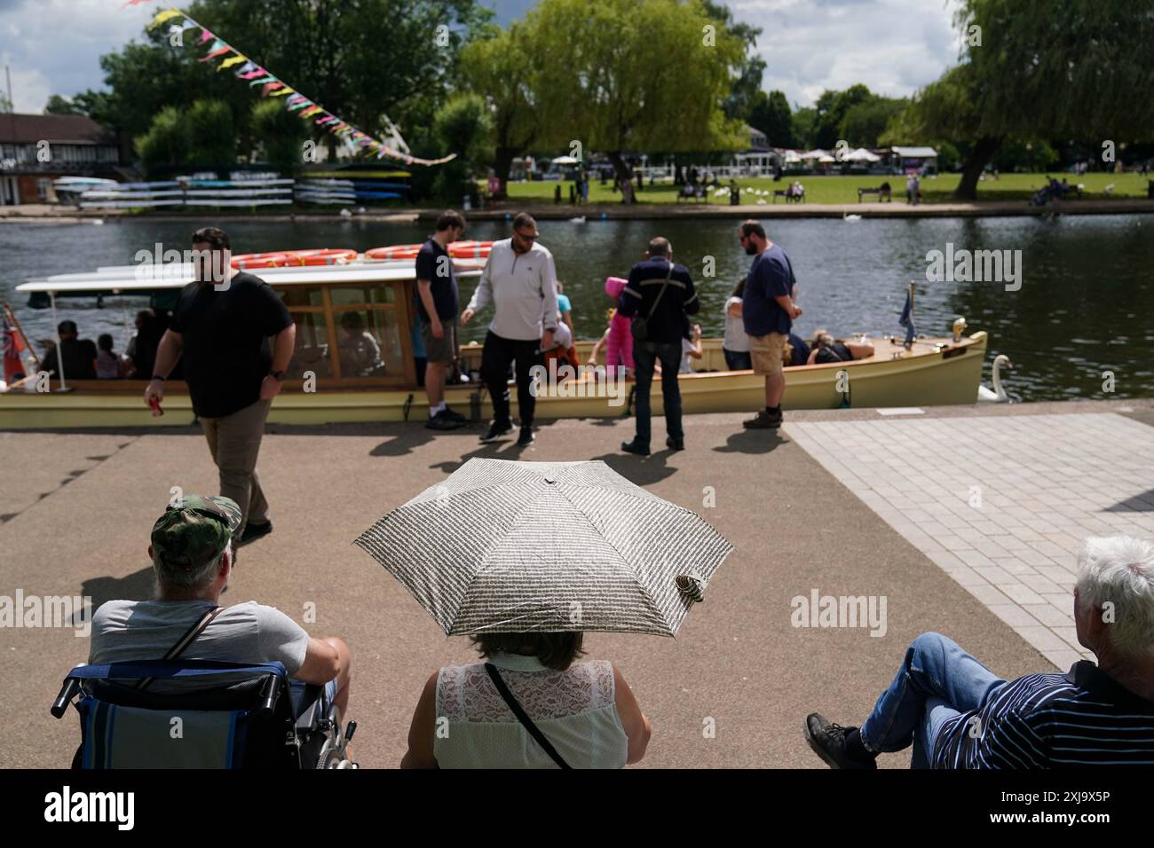 A lady uses an umbrella to shield herself from the sun in Stratford ...