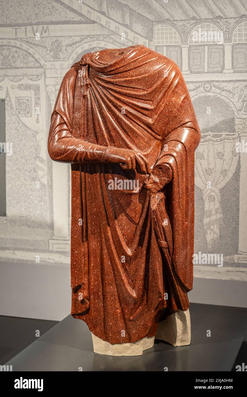 Ancient headless statue in red marble of ancient roman tunic on a male ...