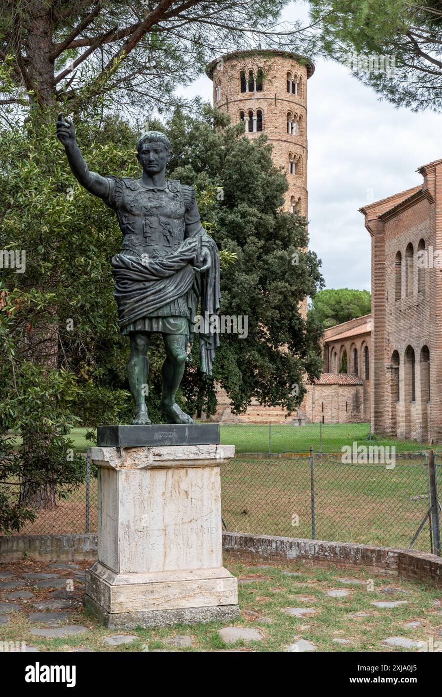 Metal statue of roman emperor standing in front of tower of medieval ...