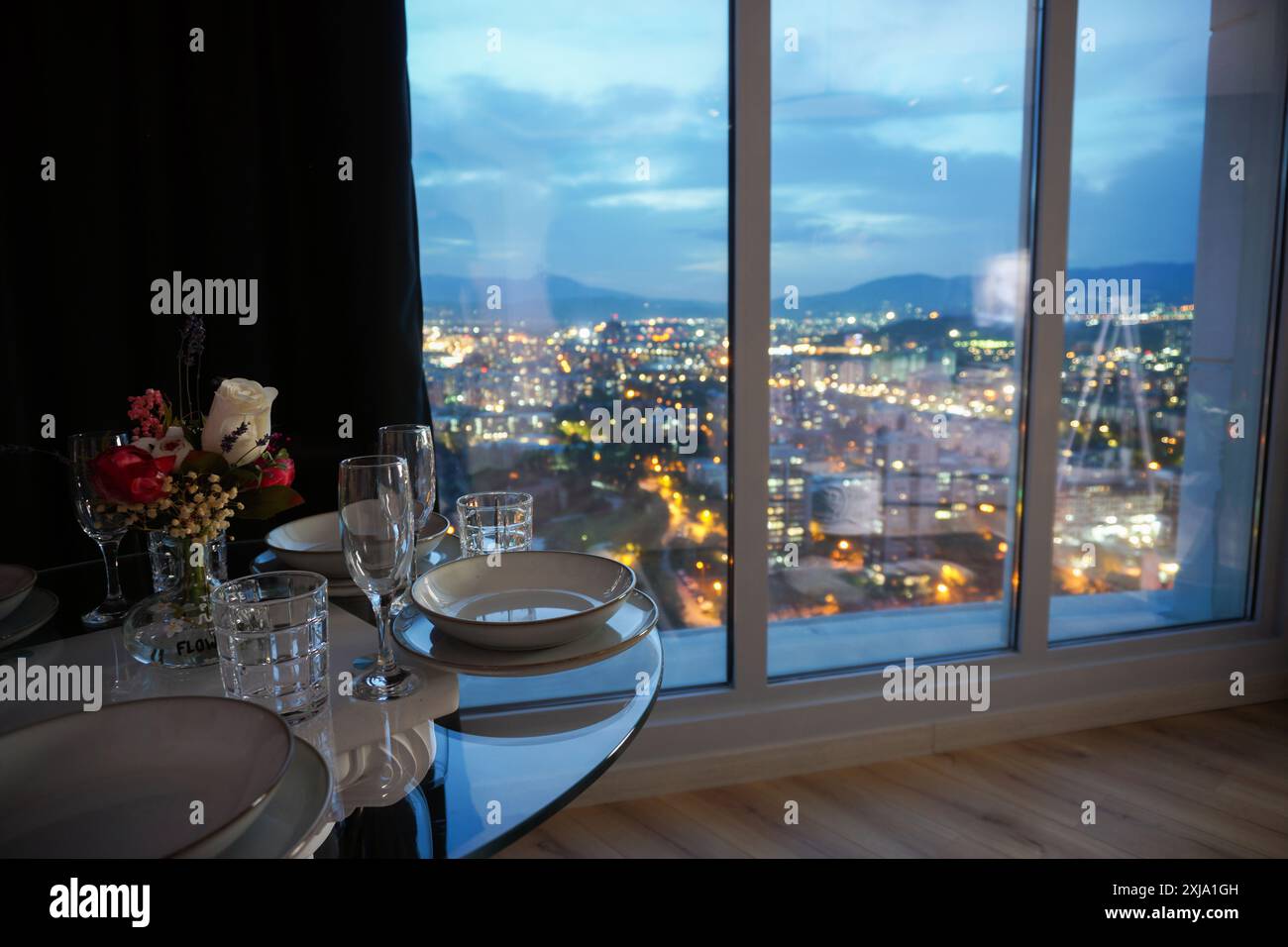 Romantic luxury dining table setting next to window with night city ...
