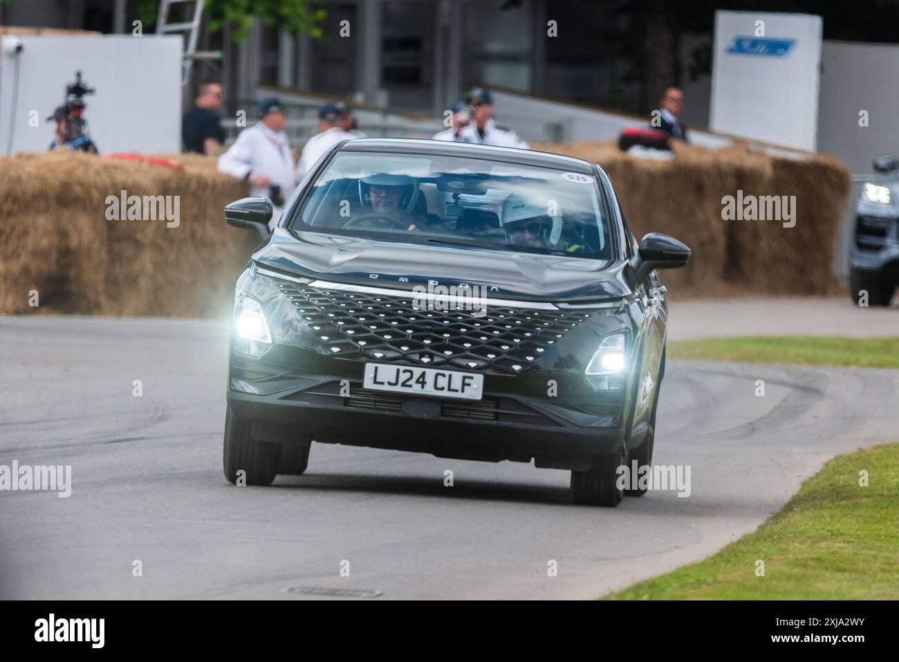 2024 Omoda 5 compact crossover SUV car driving up the hill climb track ...