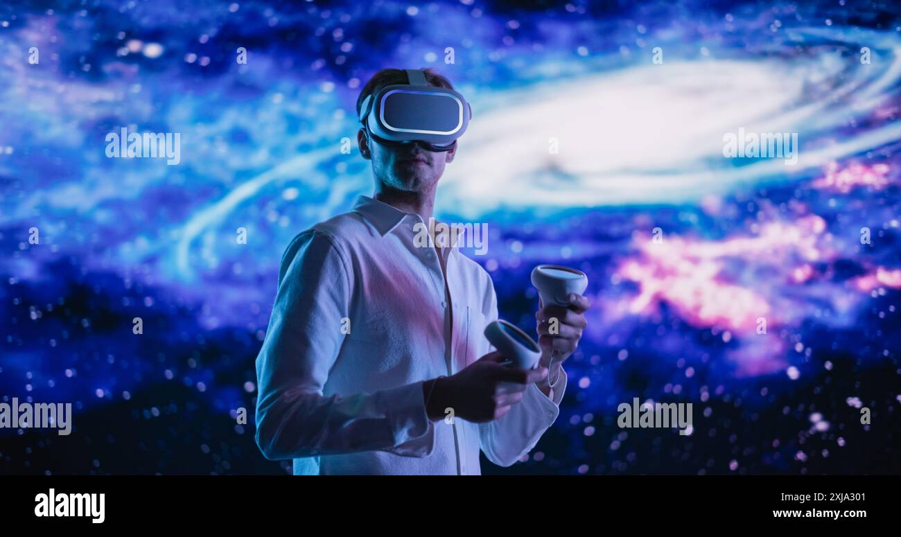 Young Male Wearing a Virtual Reality Headset and Using Controllers in a ...