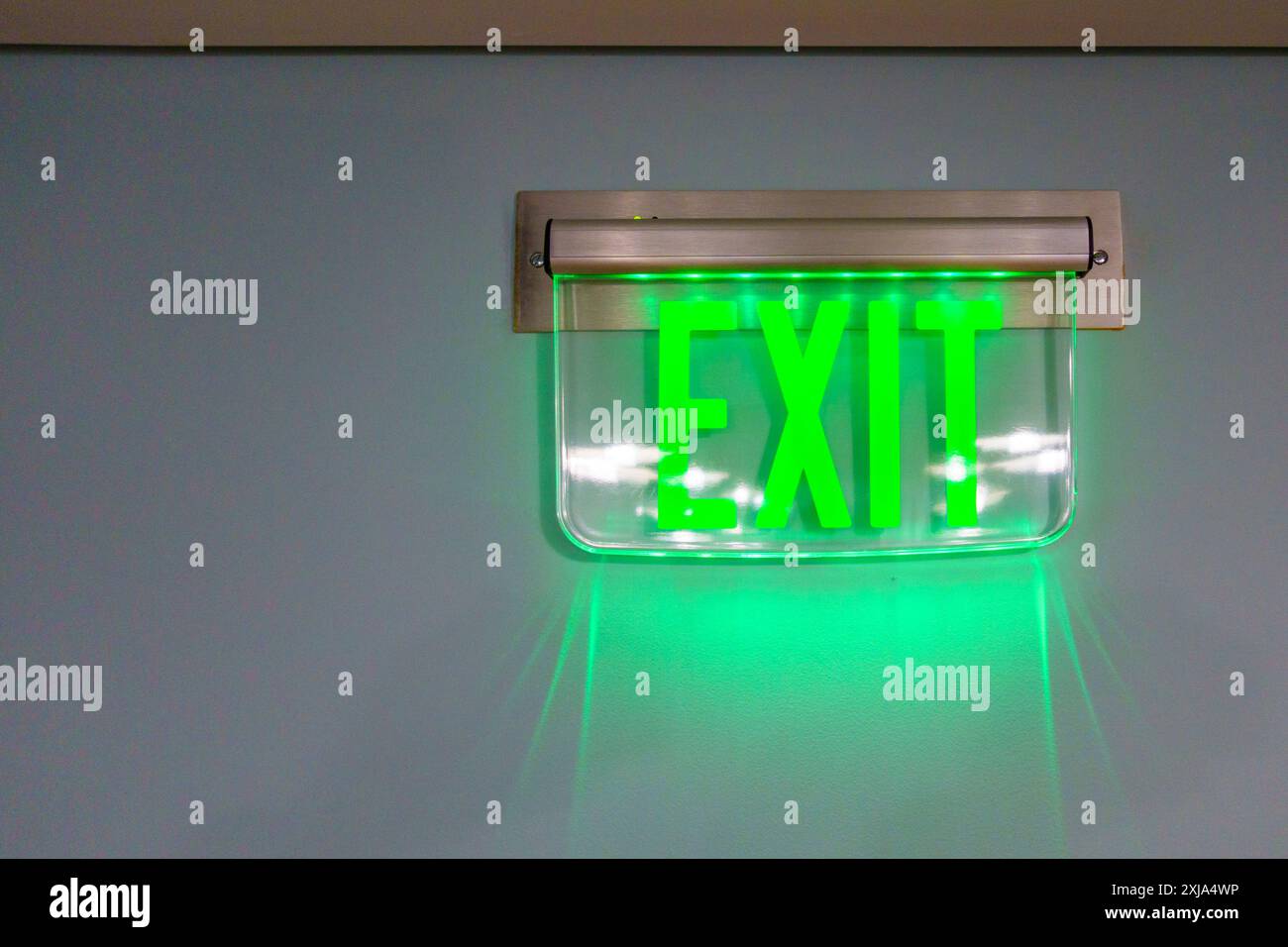 Lit exit sign on a wall Stock Photo - Alamy