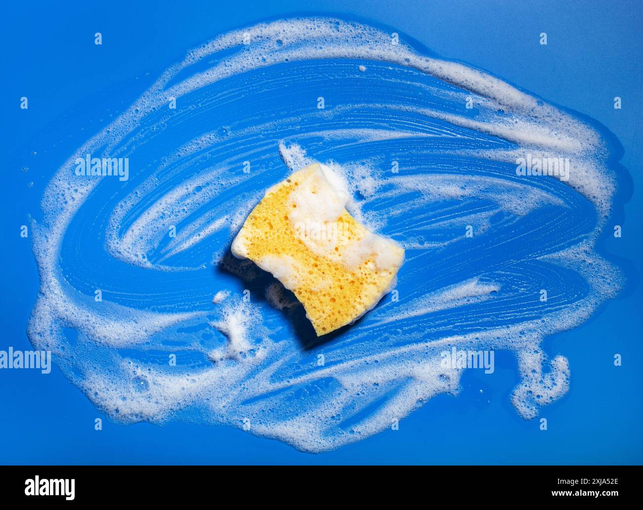 cleaning sponge wiping foam soap suds on blue background, household ...