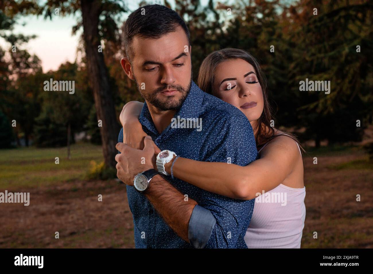 A woman with her eyes closed rests her head on a man's shoulder as they ...