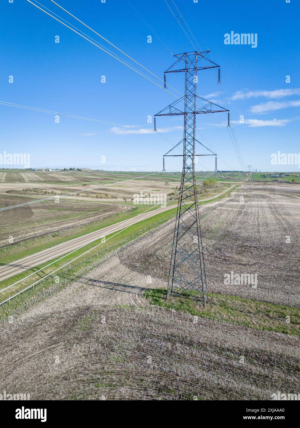Isolated electrical pylon standing tall on agriculture fields with ...