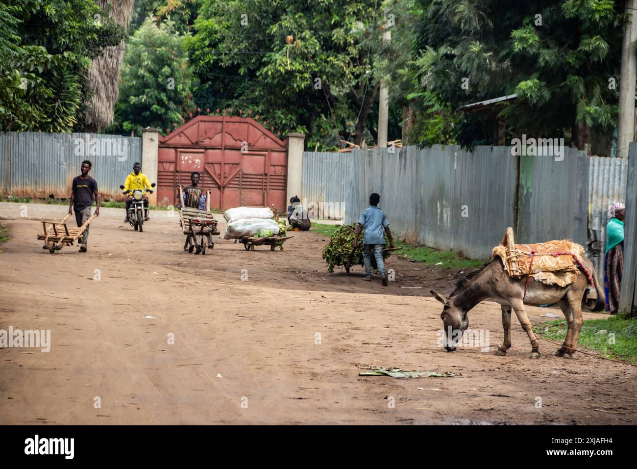 Dusty and Colorful African Village Street Scene with People passing and ...
