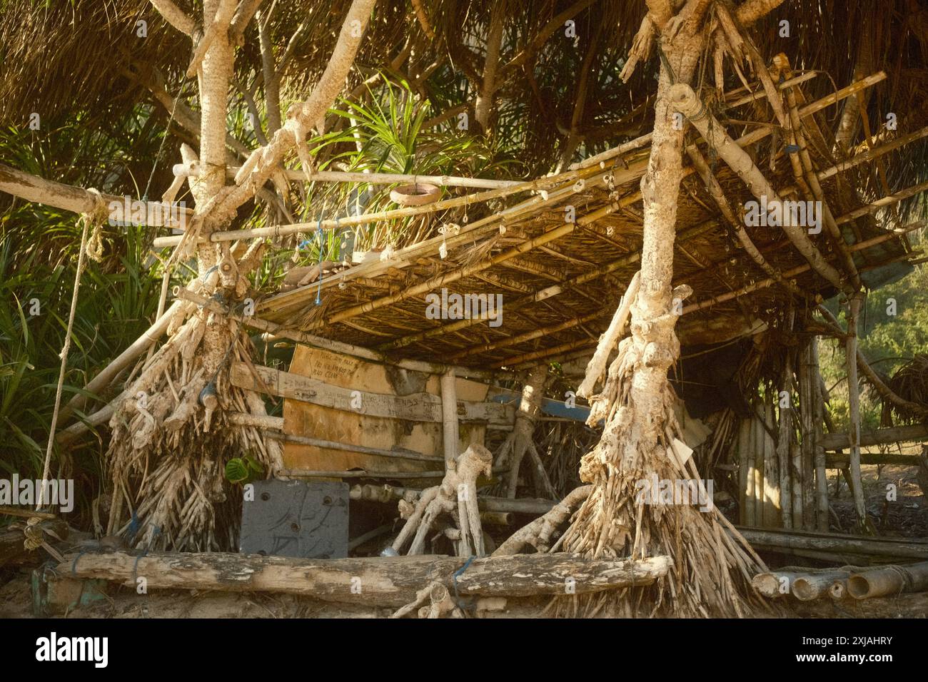 A rustic bamboo shelter using branches of wild plants and other natural ...