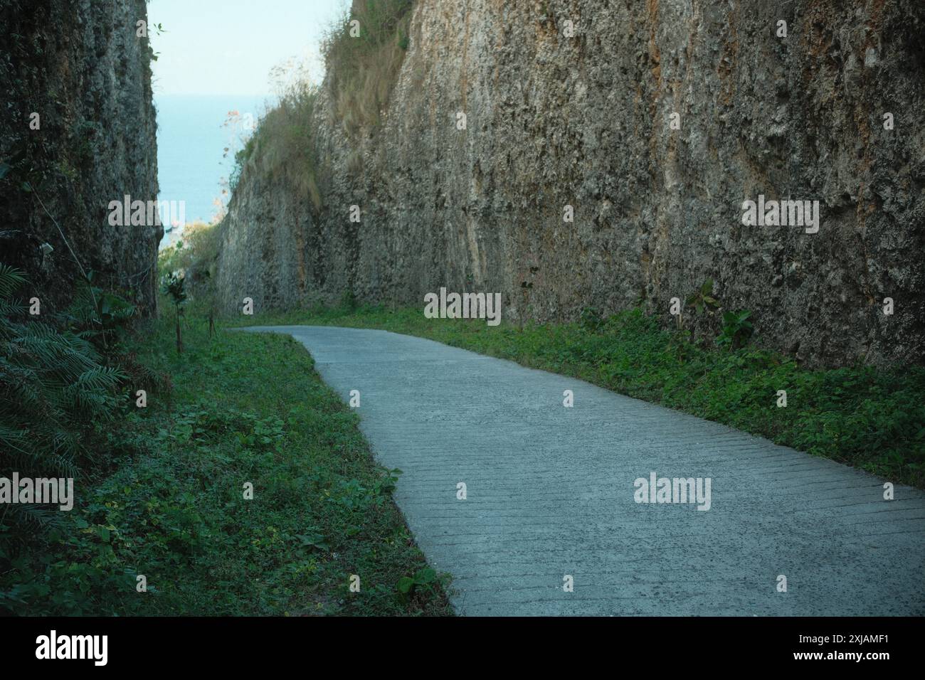 The pathway between two large cliffs leads towards the sea Stock Photo ...