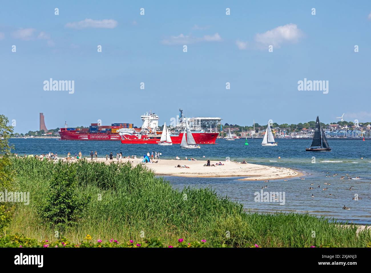 Container ship, regatta convoying ship Aquanaut, sailing boats, people ...