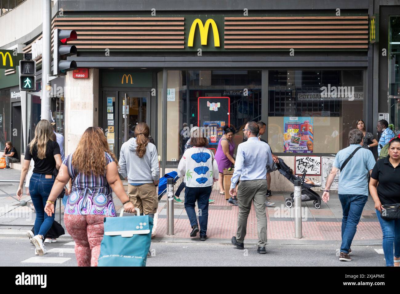 Pedestrians cross the street in front of an American multinational fast ...