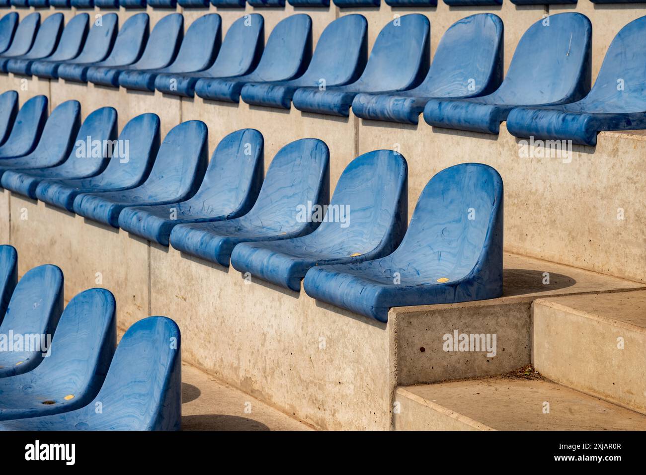 long rows of blue seats on a sports field stand Stock Photo - Alamy