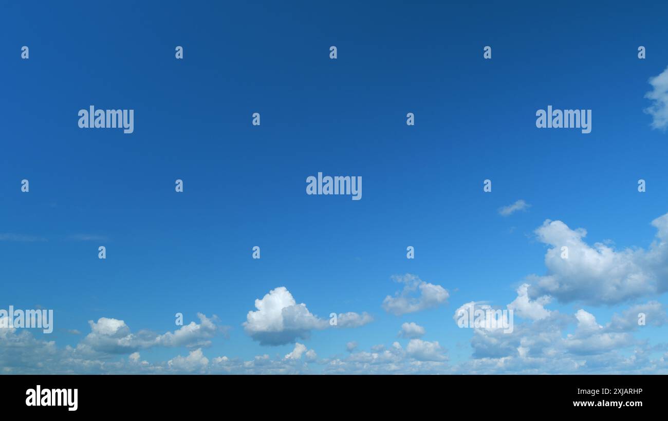 Time lapse. White and gray clouds fly across the sky and change shape ...