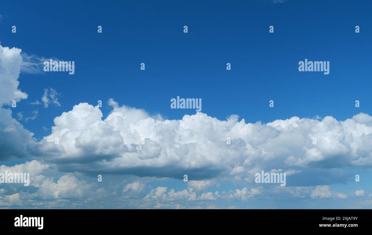 Time lapse. Clouds running across the blue sky. White puffy and fluffy ...