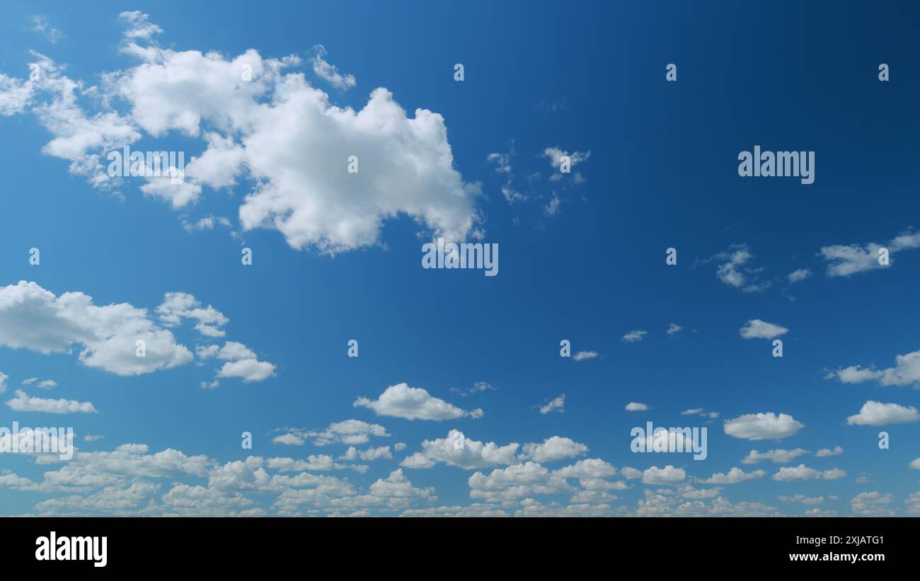 Time lapse. White and gray clouds fly across the sky and change shape ...
