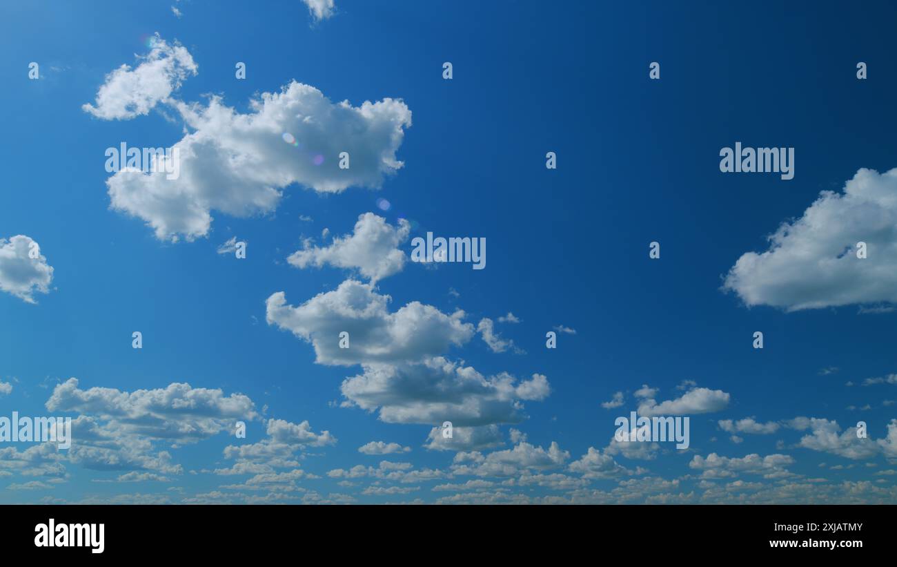 Time lapse. White and gray clouds fly across the sky and change shape ...