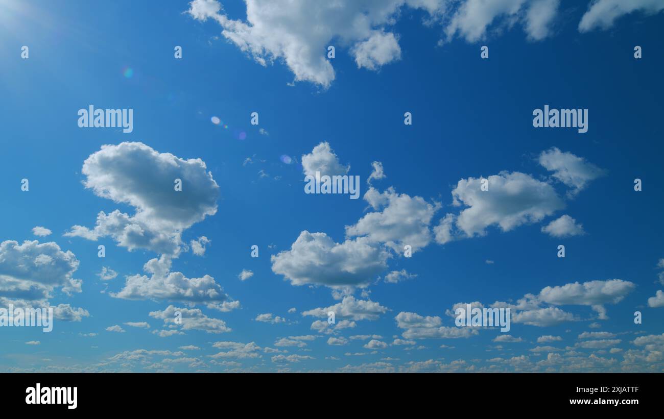Time lapse. Clouds running across the blue sky. White puffy and fluffy ...