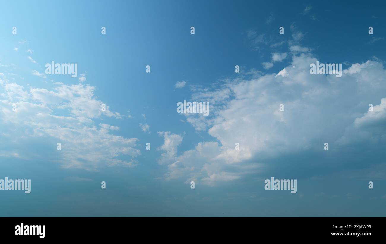 Time lapse. White and gray clouds fly across the sky and change shape ...