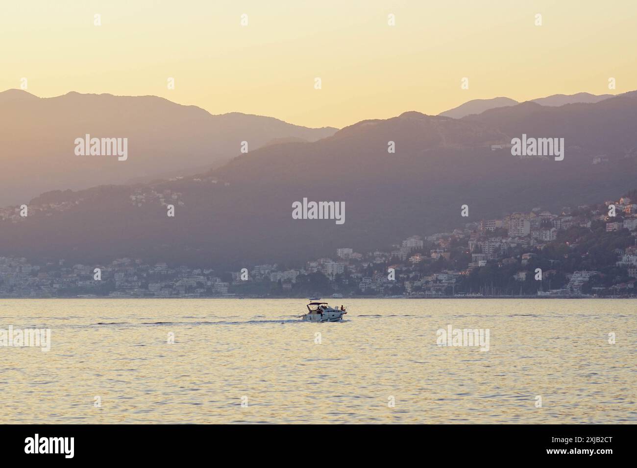 A distant view of a small boat sailing on a summer evening to the ...