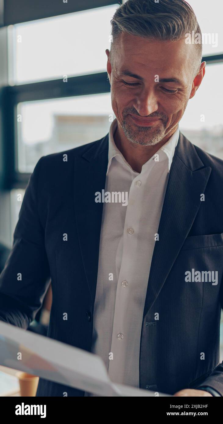Mature businessman manager is holding documents consulting client at ...