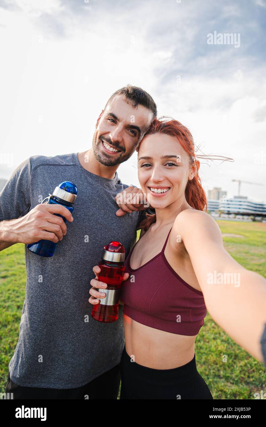 Vertical Sport couple taking a selfie portrait after the cardio workout ...