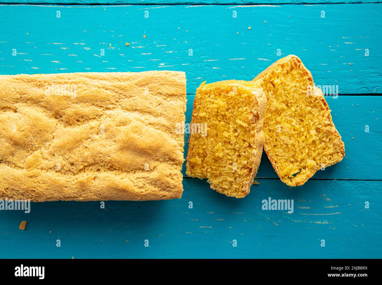 Beautiful homemade yellow sliced cornbread loaf on blue wood board ...