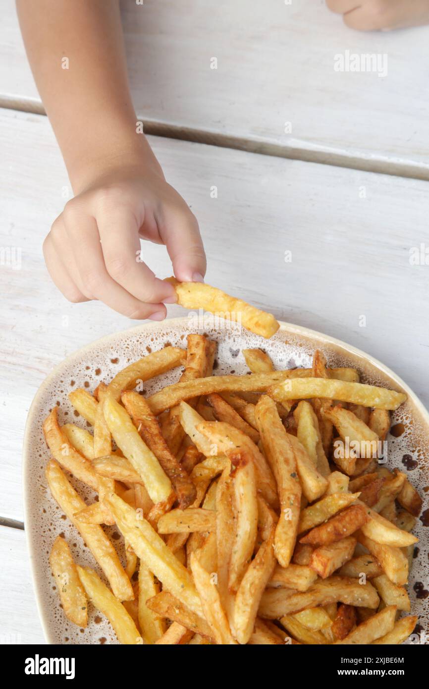 Little girl is eating french fries Stock Photo - Alamy