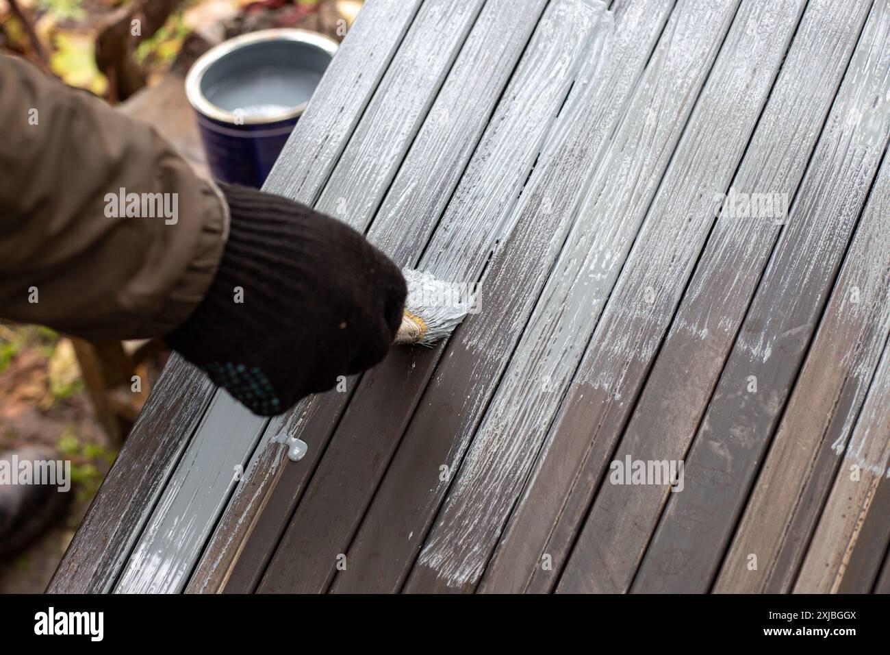 Painting the metal profile with gray paint. Construction materials are ...