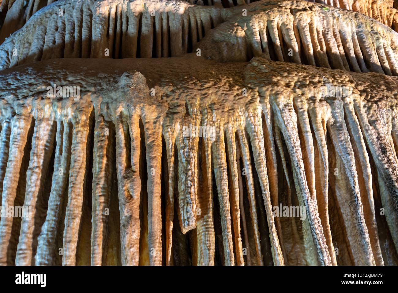A detailed view of stalactites in a cave, characterized by elongated ...