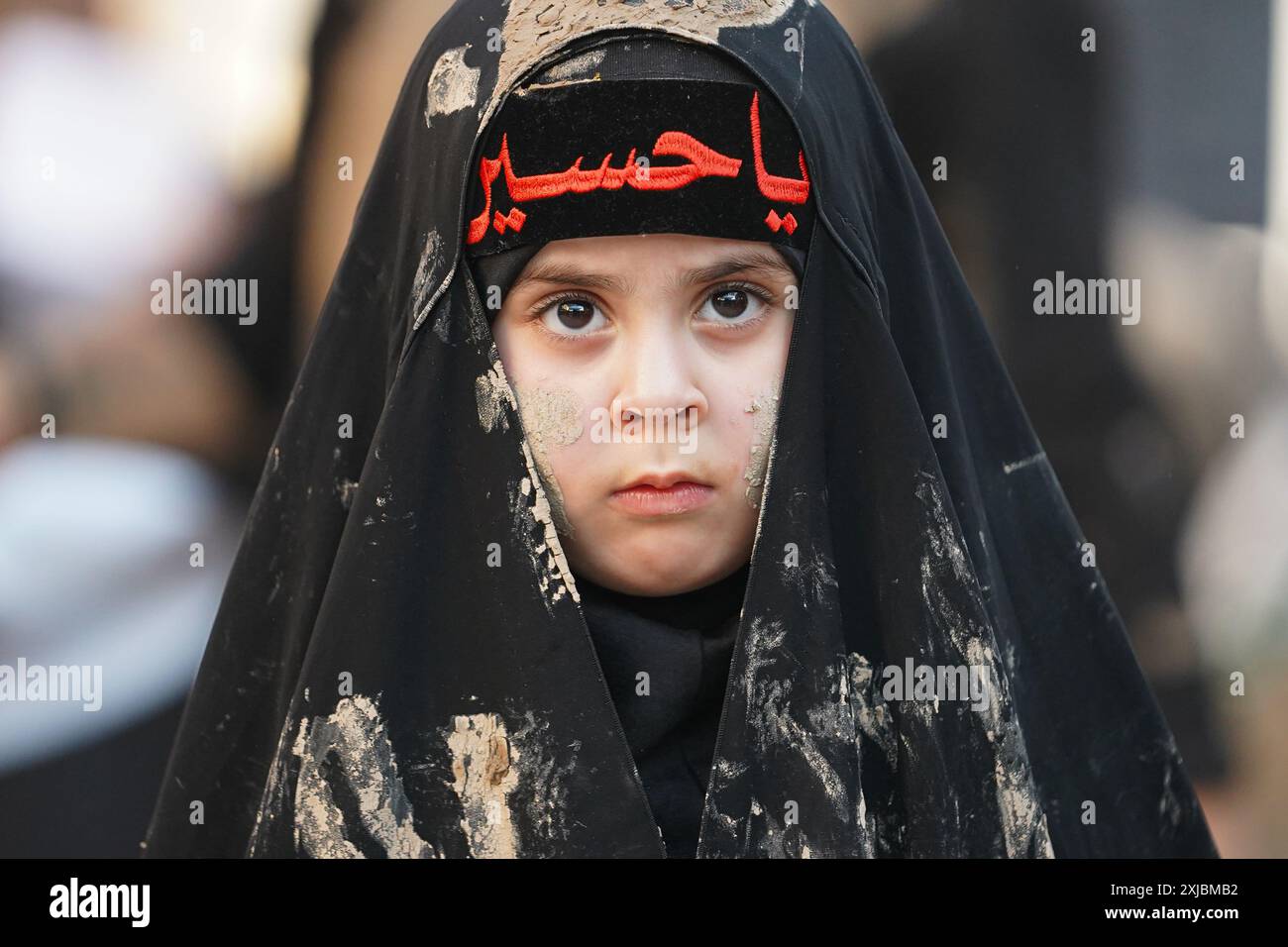 An Iraqi Shiite Muslim child smeared her face with mud while ...