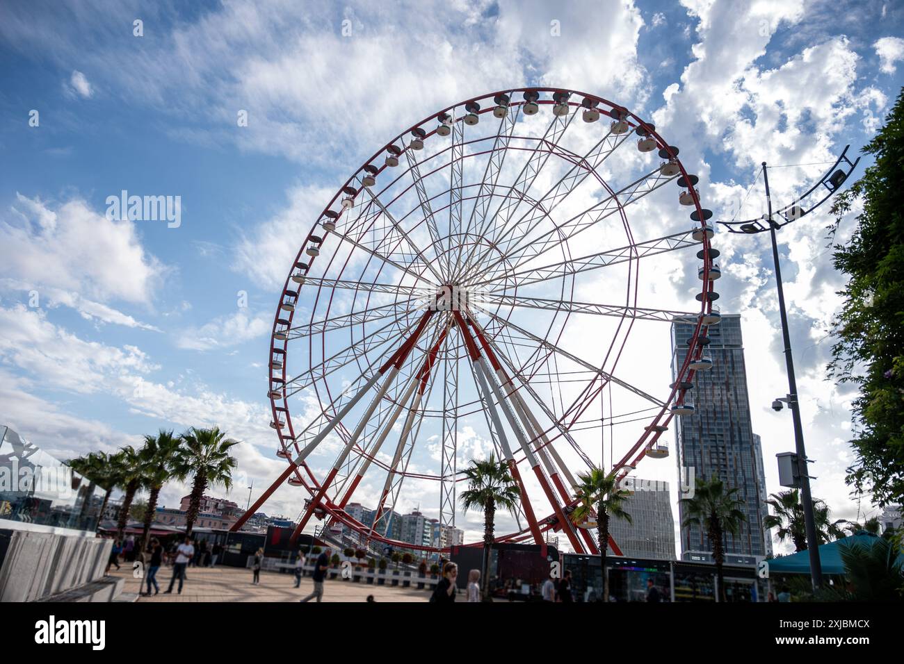 Red and White Ferris Wheel Against Blue and Cloudy Sky with Copy Space ...