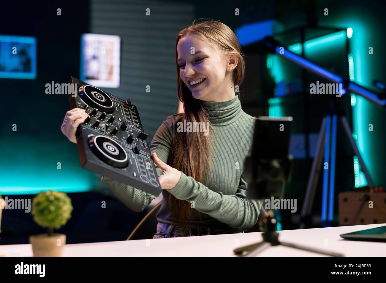 Joyous influencer filming DJ mixing tutorial in home studio, showing examples of sampling on ...