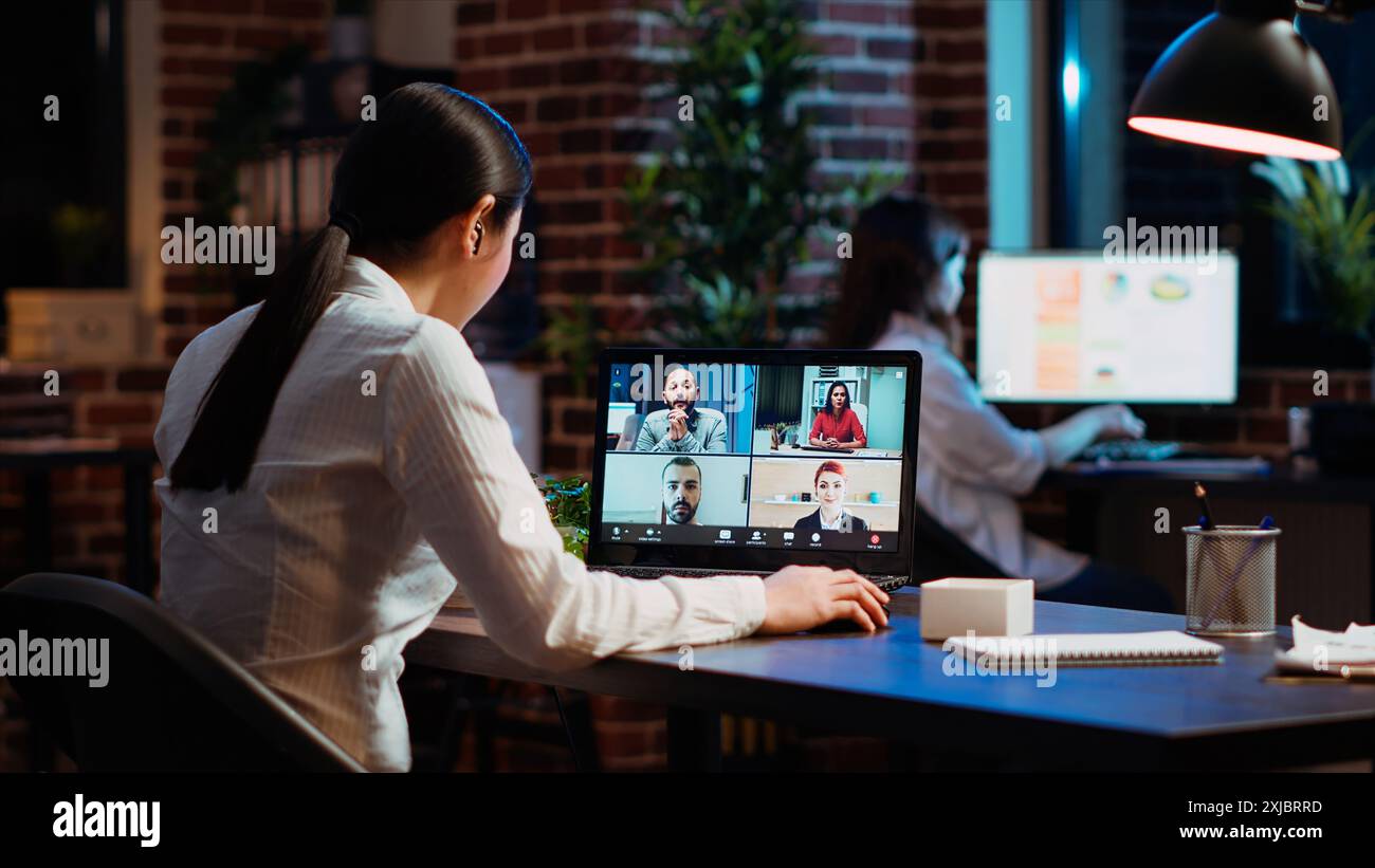 Staff member discussing with members of board of directors during company meeting on videocall ...