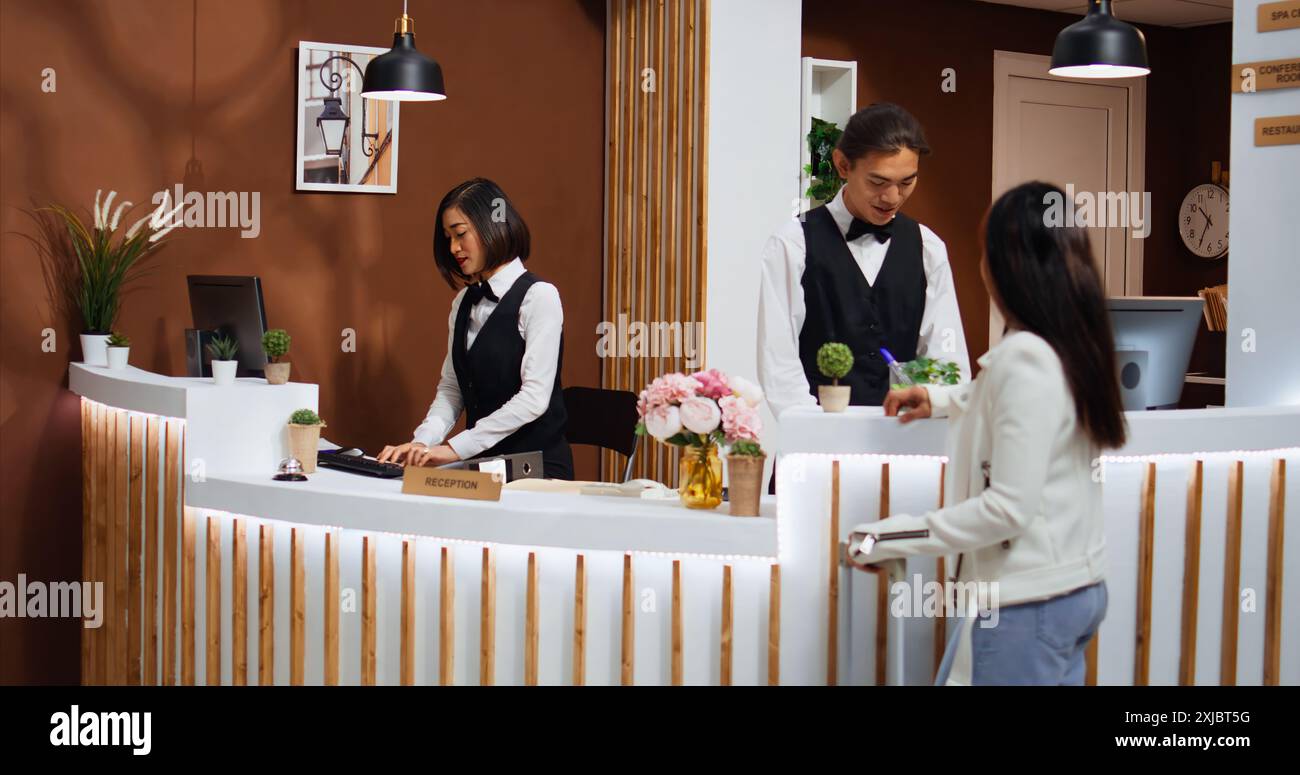 Tourist entering hotel reception to go through registration, confirming ...