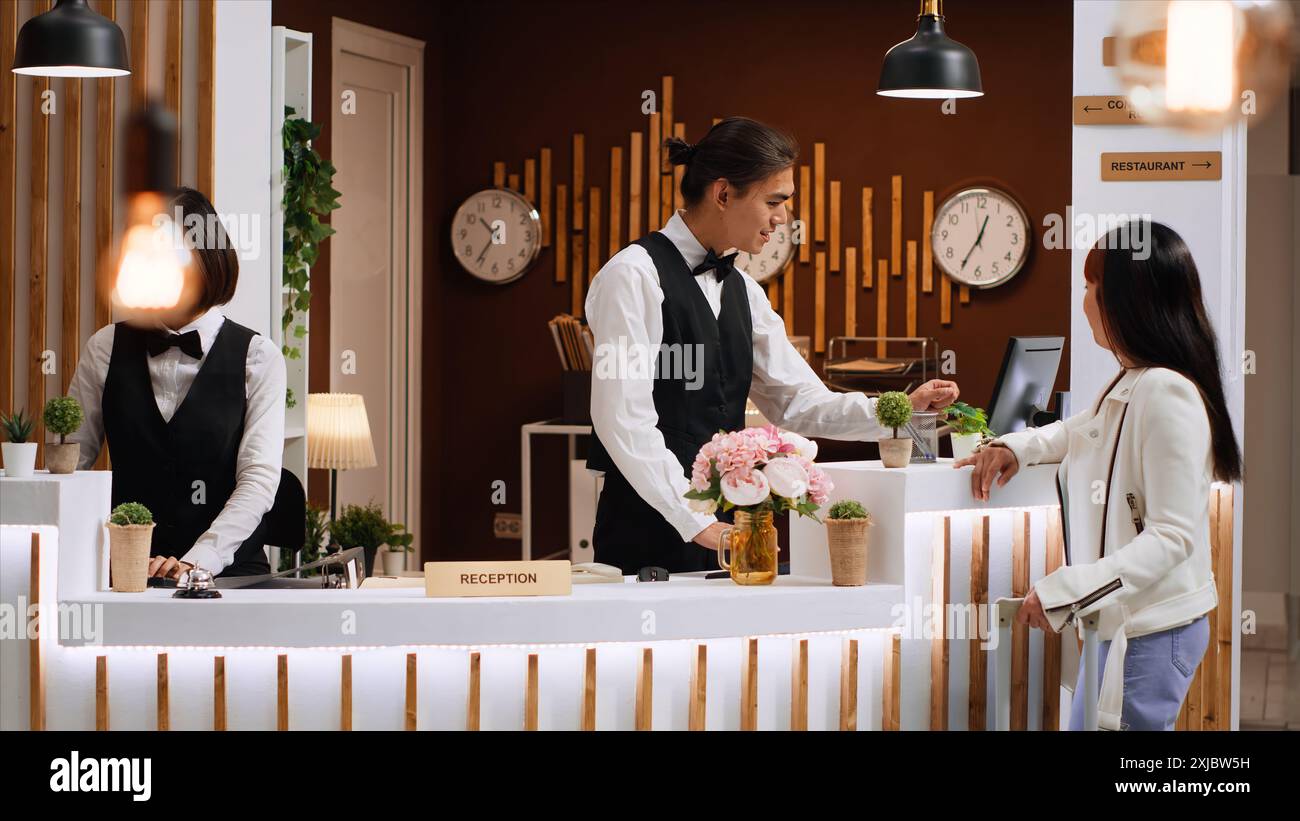 Asian guest arriving at hotel and asking about room reservation ...