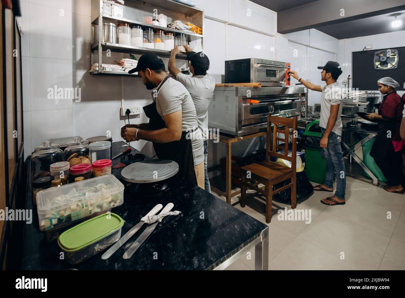 Kitchen staff work in modern environment with stainless steel ...