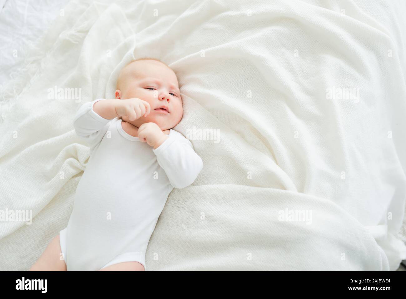 Happy baby. Cute little newborn girl with smiling face lying on bed in ...