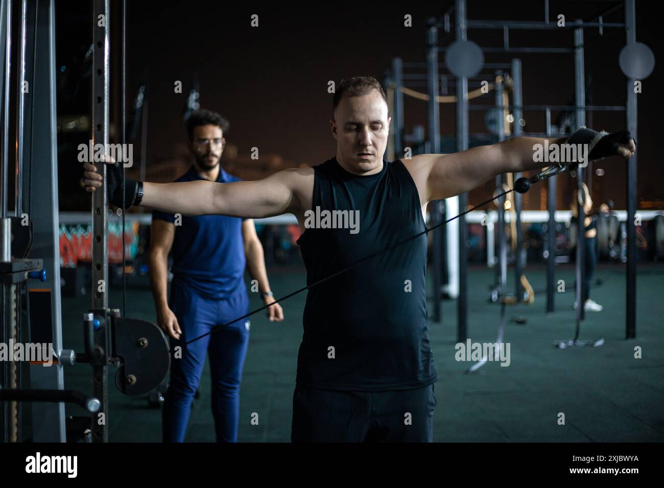 Man Performing Cable Fly Exercise At Night In Gym Stock Photo - Alamy
