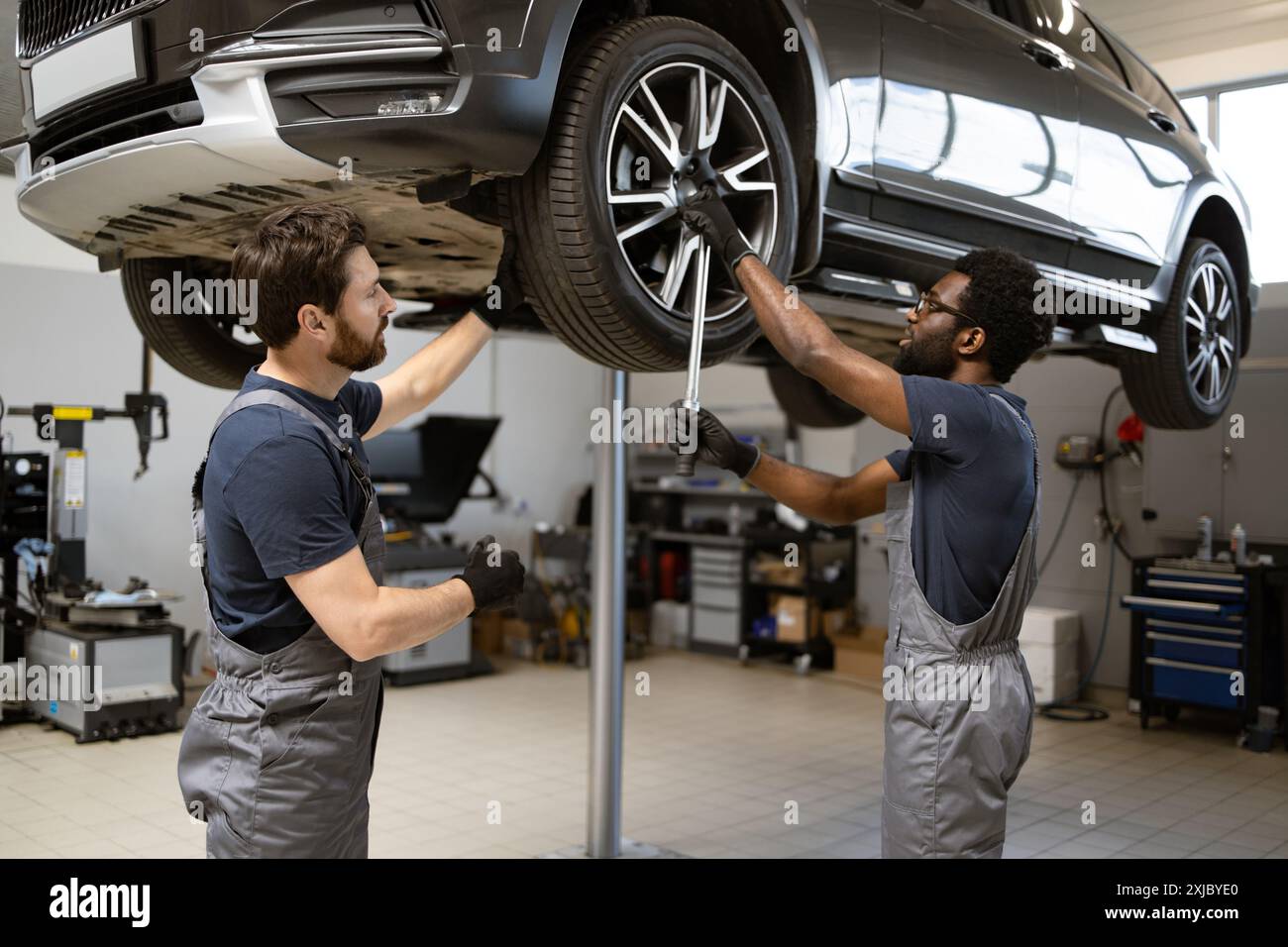Car mechanics working on vehicle maintenance in modern garage Stock ...