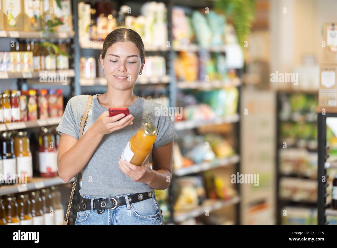 Female shopper scanning QR code on juice bottle in store Stock Photo ...