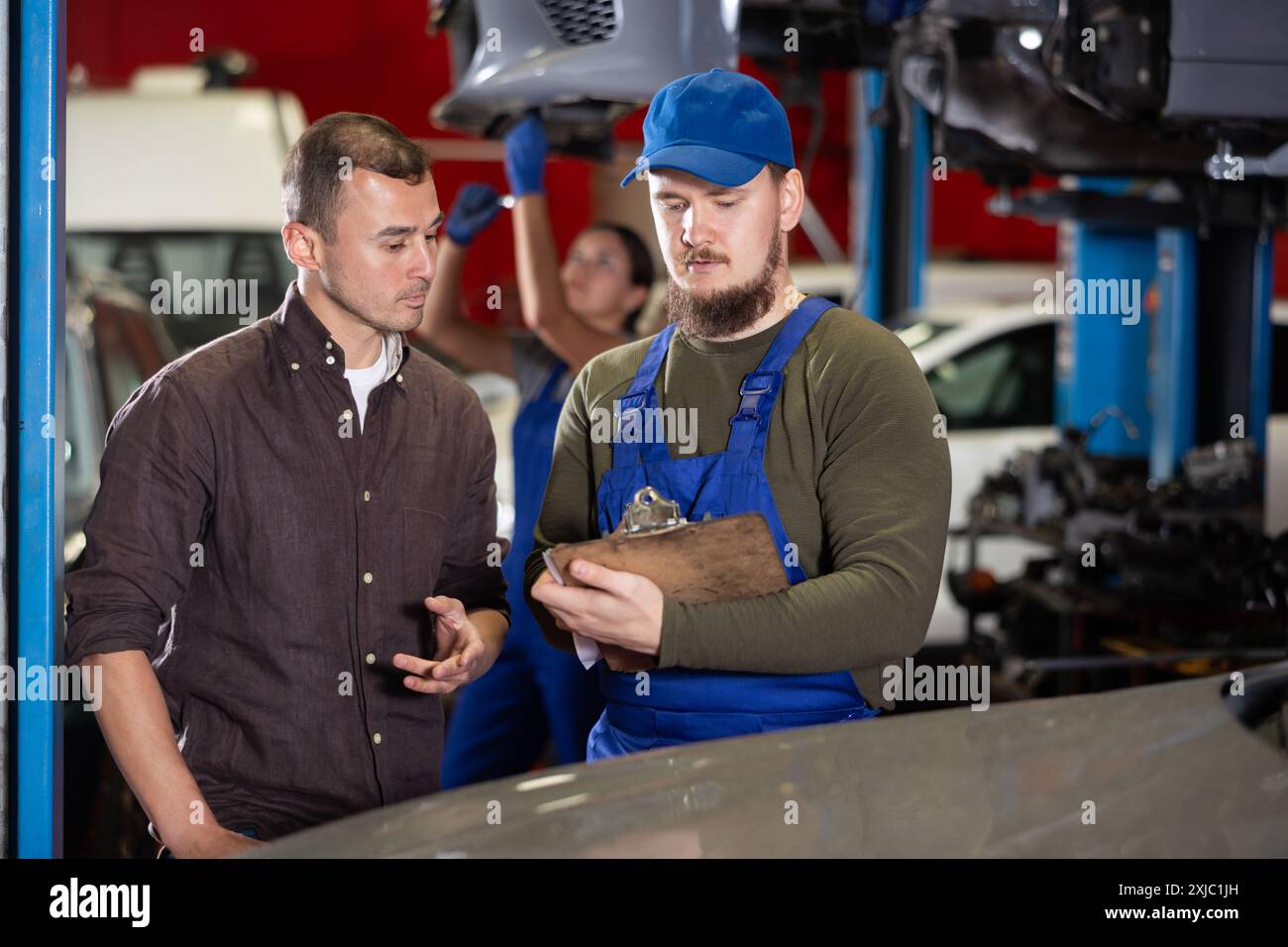 Owner of car explains to mechanic what needs to be repaired. Auto ...
