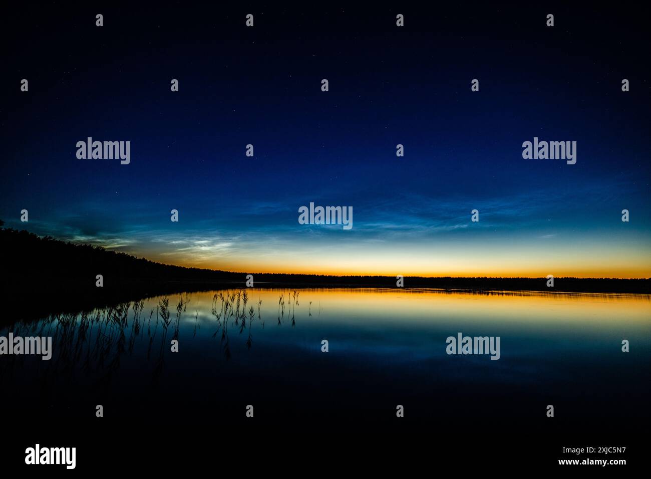 Lake at night, sky with stars, reflection in water, noctilucent clouds ...