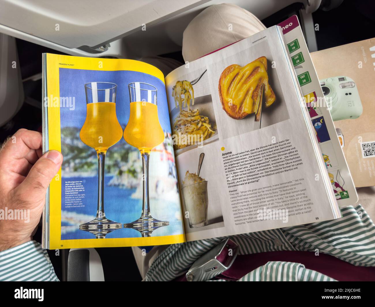 Germany - Jul 11, 2024: A passenger reads the Wings Shop magazine in a ...