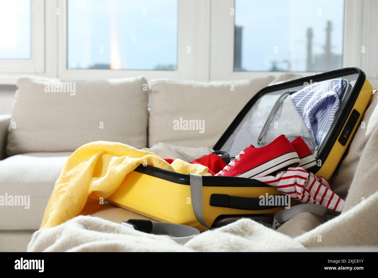 Open suitcase with traveler's belongings on bed, closeup Stock Photo ...