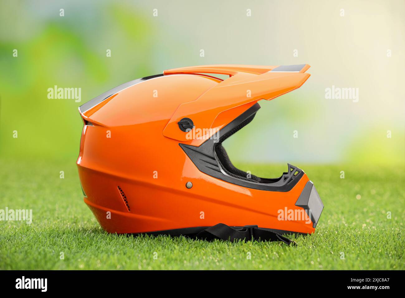 Orange motorcycle helmet with visor on green grass Stock Photo - Alamy