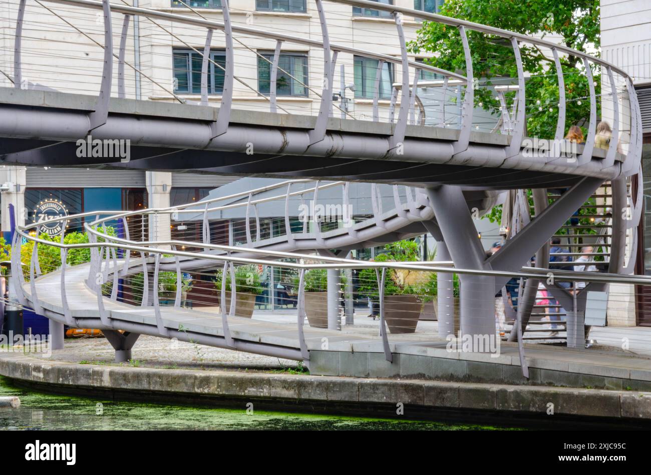 A spiralling ramp and steps leading up to a footbridge across The Grand ...