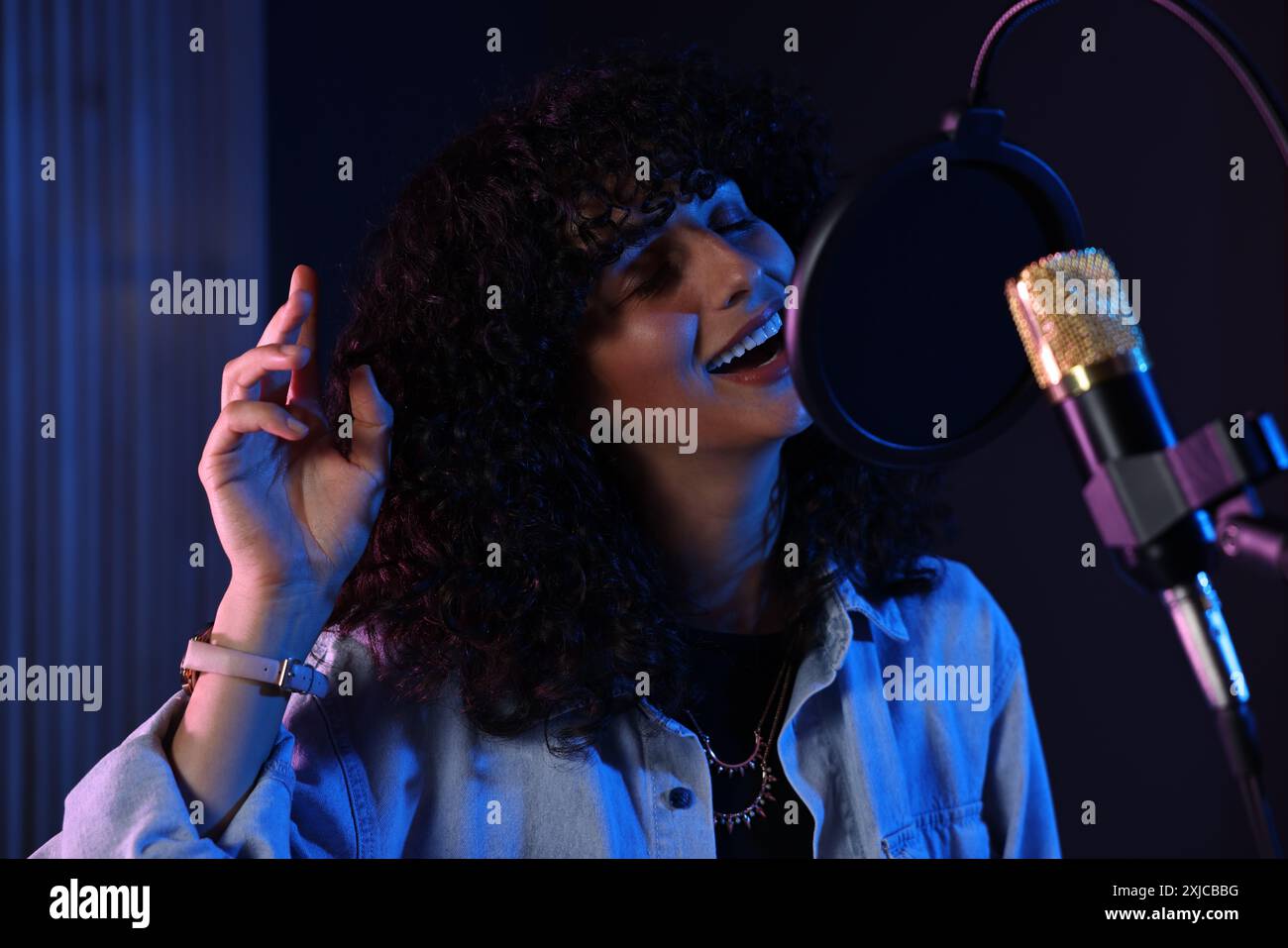 Vocalist singing into microphone in professional record studio Stock ...