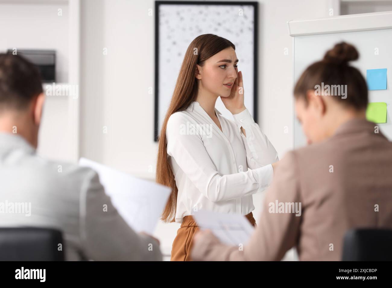 Woman feeling embarrassed during business meeting in office Stock Photo ...