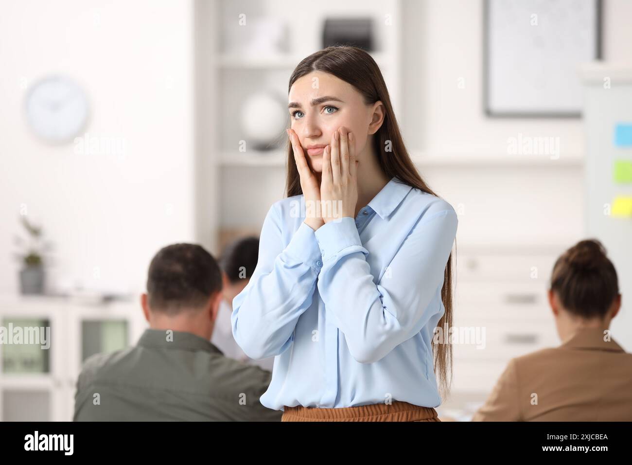 Woman feeling embarrassed during business meeting in office Stock Photo ...
