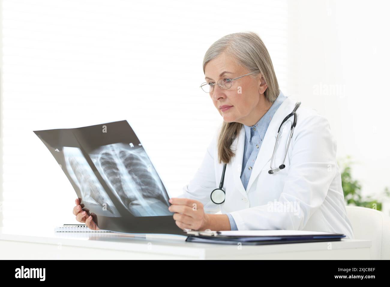 Lung disease. Doctor examining chest x-ray at table in clinic Stock ...